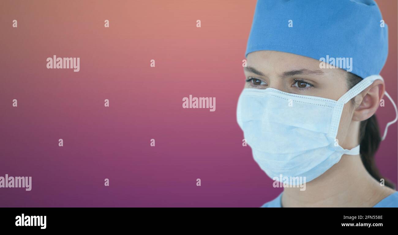 Female surgeon wearing surgical mask against pink gradient background ...
