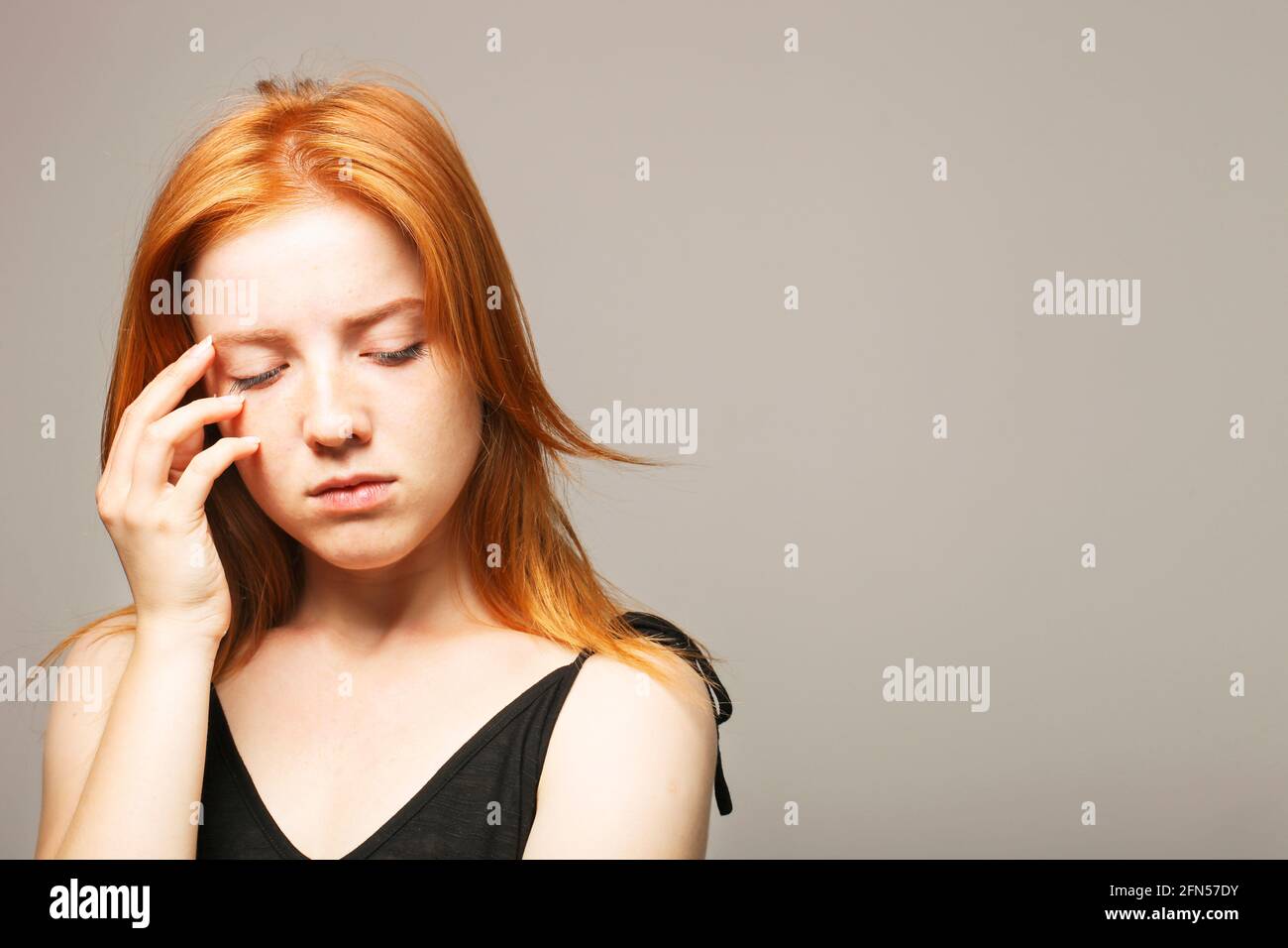 Beautiful fragile redheaded young woman in the dark. Sad frightened ...