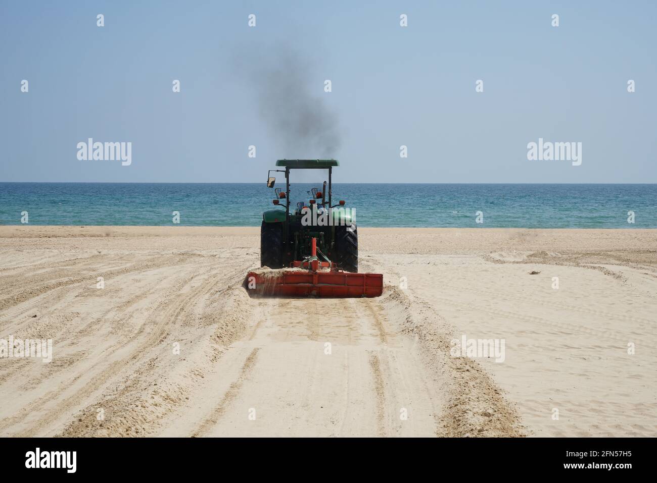 Back view of a tractor cleaning on a sandy beach Stock Photo - Alamy