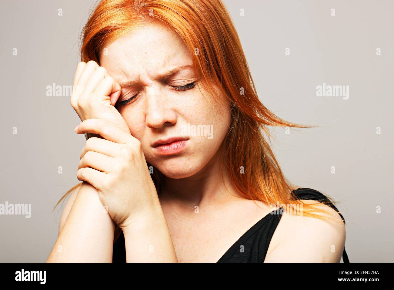 Beautiful fragile redheaded young woman in the dark. Sad frightened ...