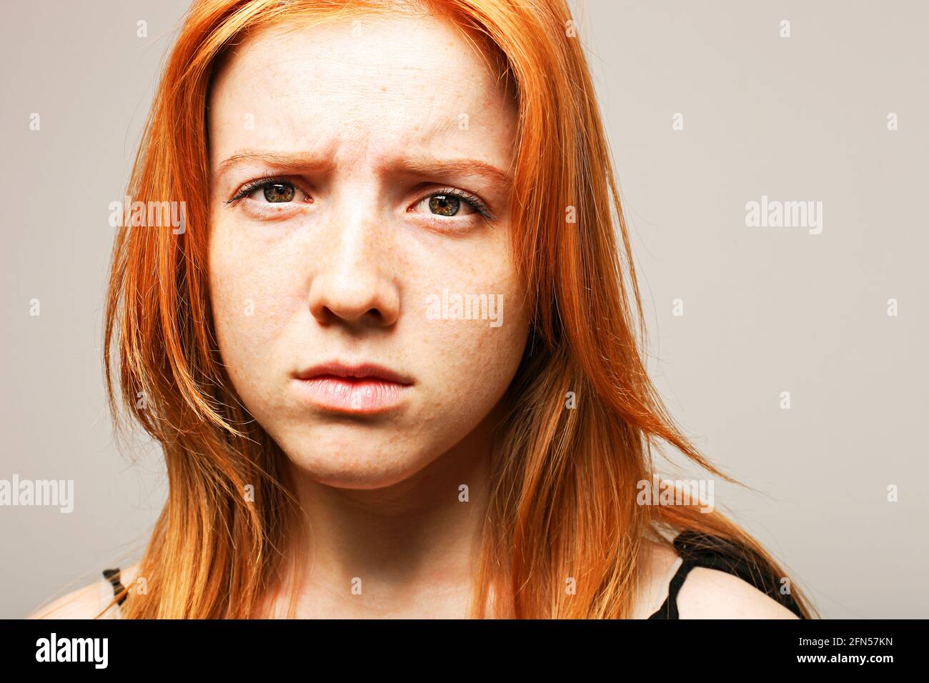 Beautiful fragile redheaded young woman in the dark. Sad frightened ...