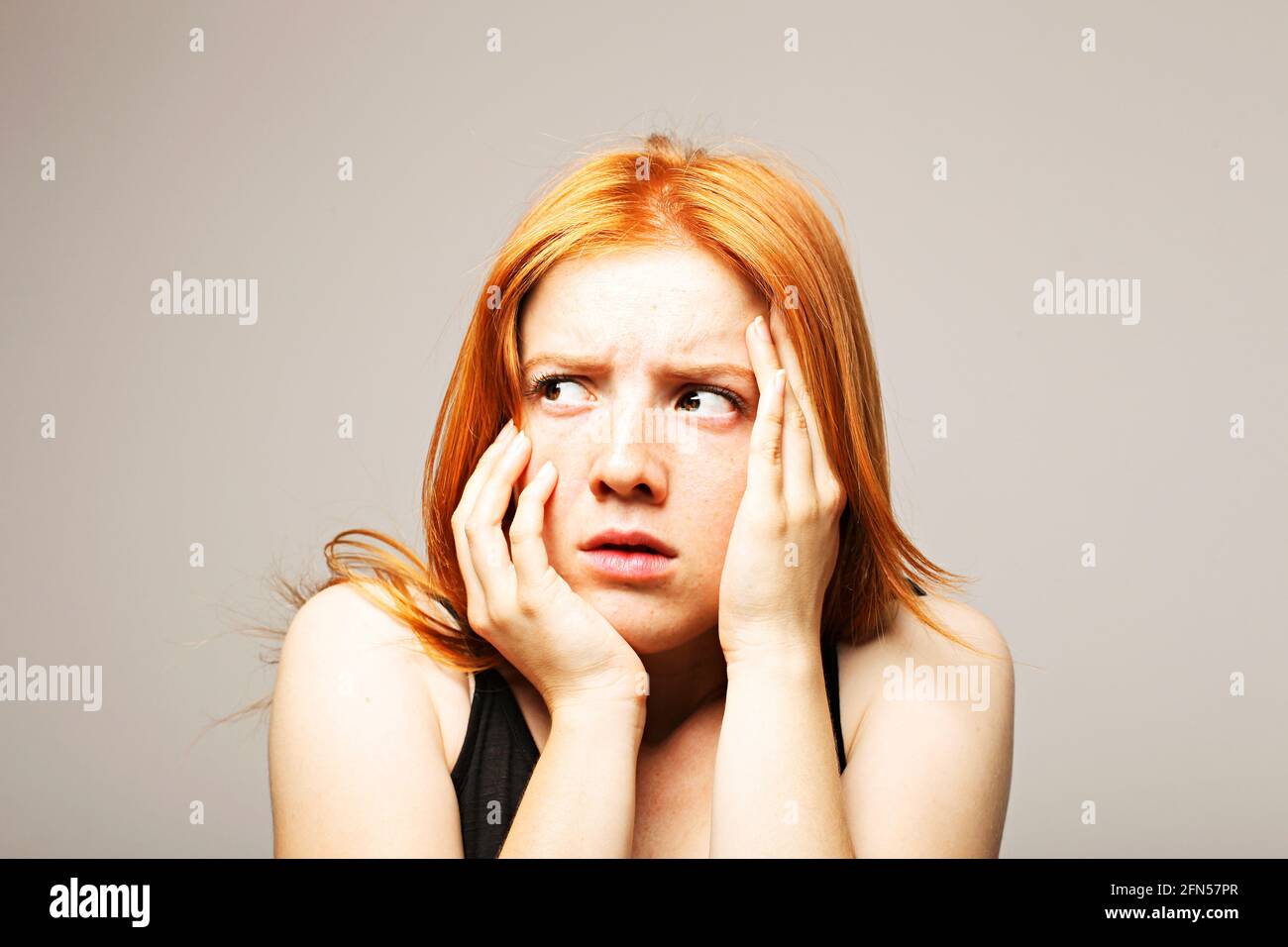 Beautiful fragile redheaded young woman in the dark. Sad frightened ...