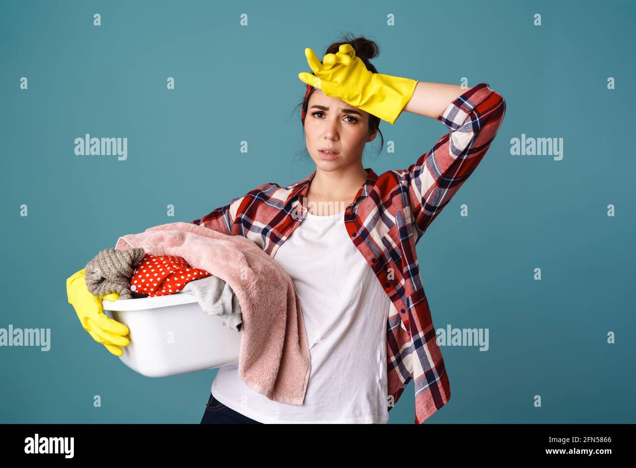 Tired beautiful girl in gloves posing with dirty clothes isolated over ...