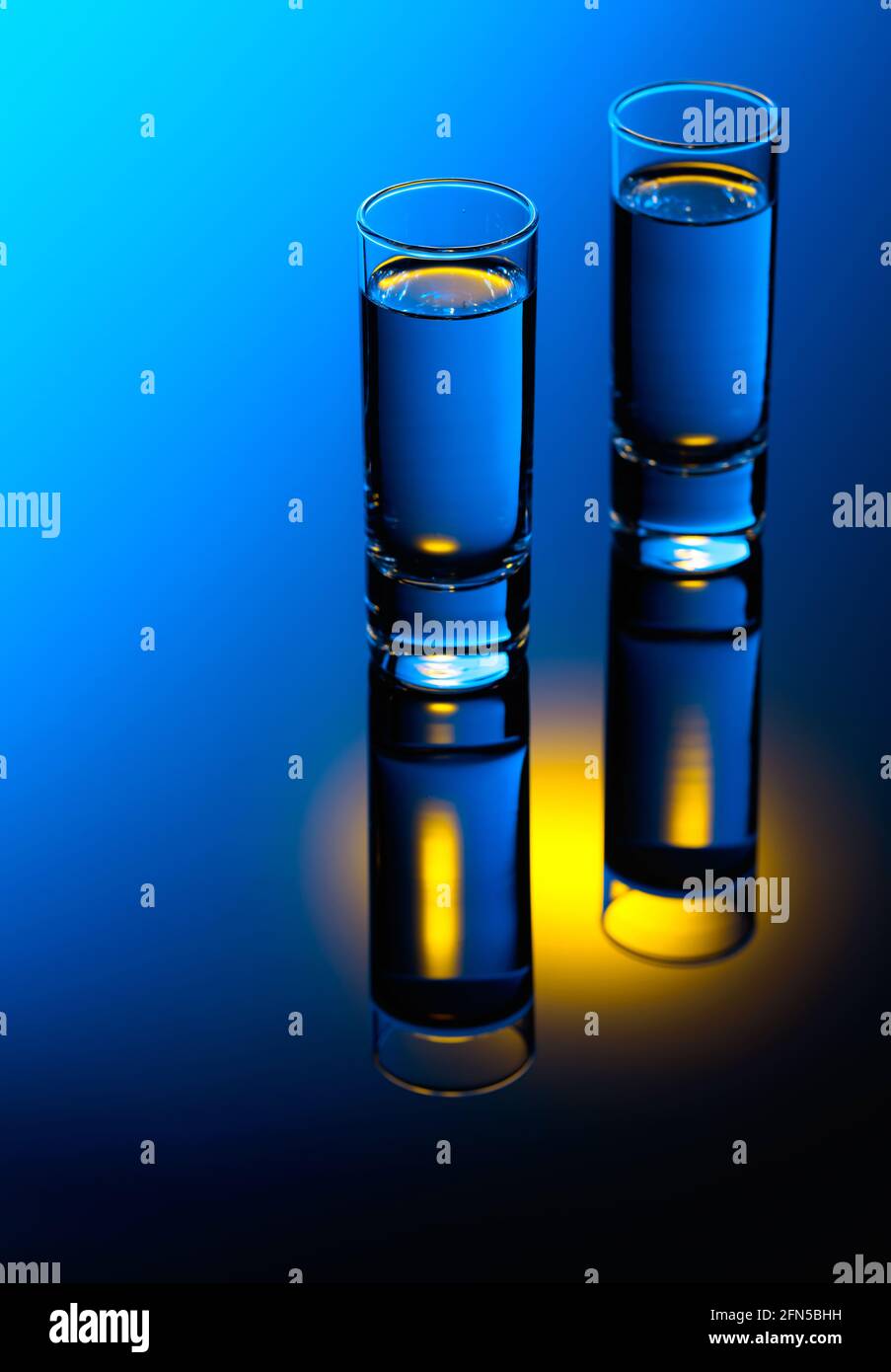 Vodka on a black reflective background. Strong alcoholic drink in color ...