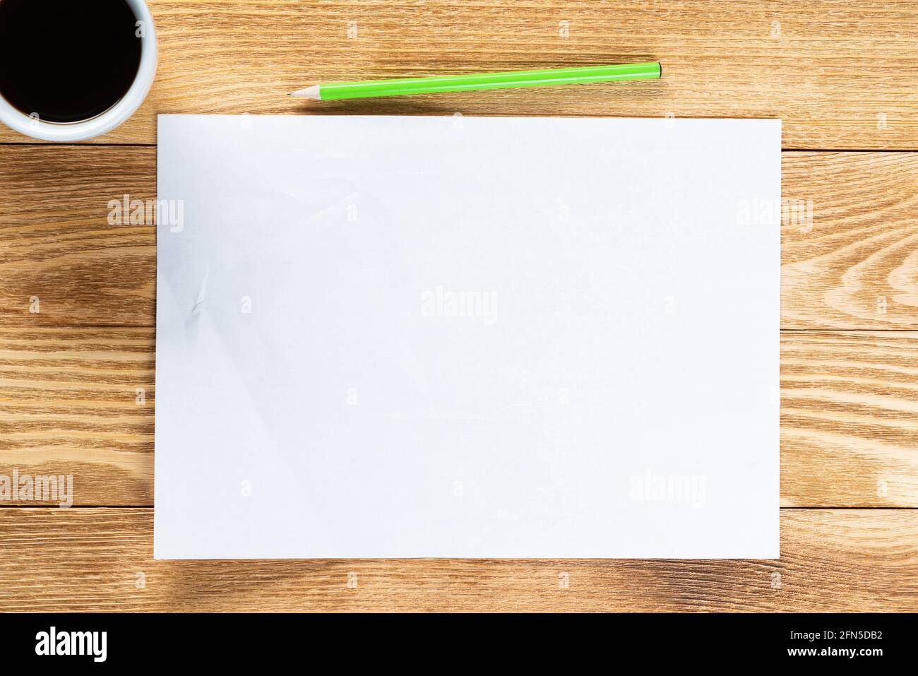 Sheet of paper lying on wooden table Stock Photo - Alamy
