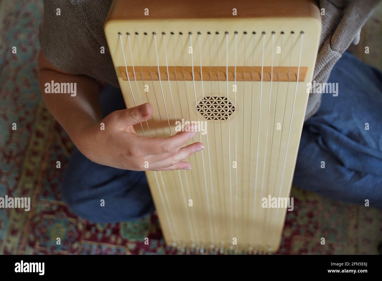 Woman holding a monochord, sound healing instrument in a therapy ...