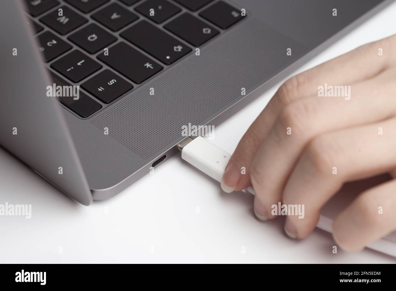 Close-up photo of a type-c cable that connected to laptop by a female ...
