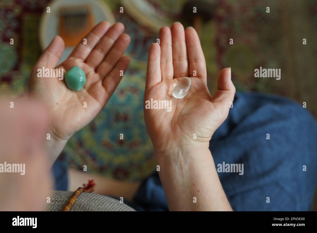 hands of a woman holding healing stones Stock Photo - Alamy