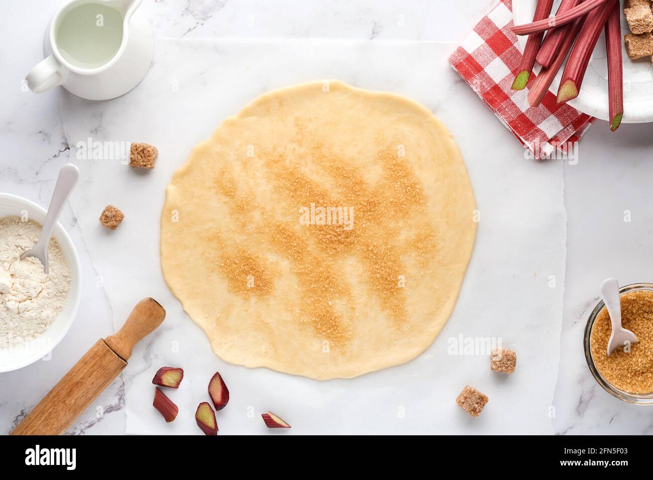 Home baking concept with raw dough rolled out with ingredients flour ...