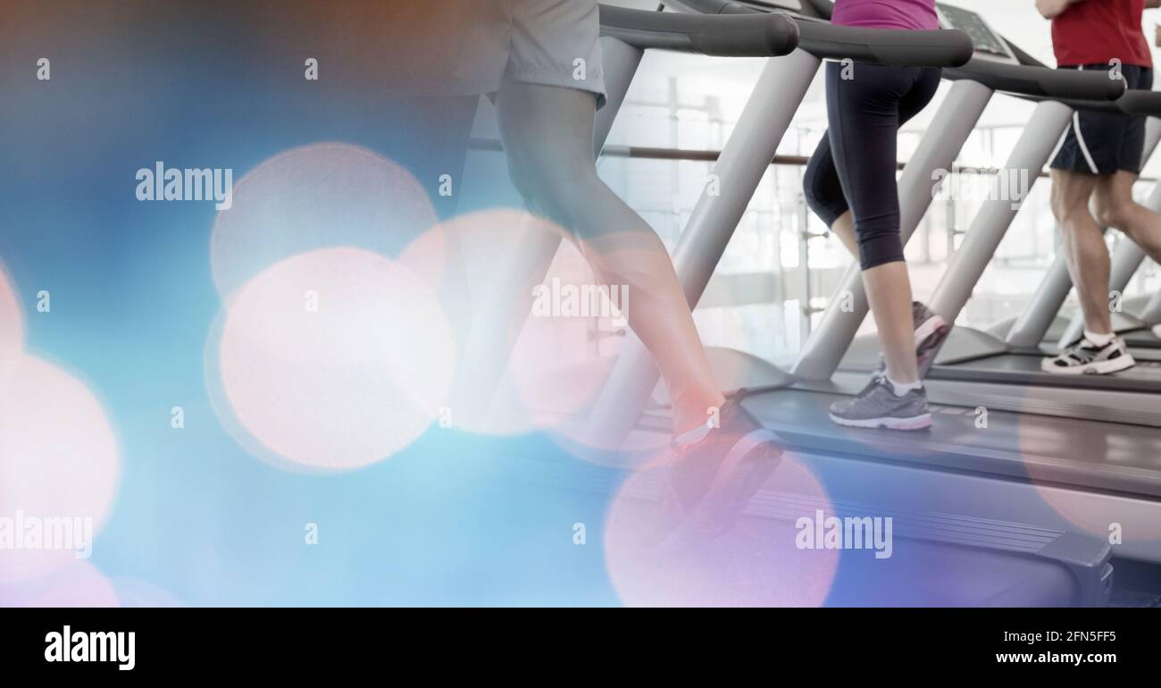 Composition of man running on treadmill with red spot on ankle showing ...