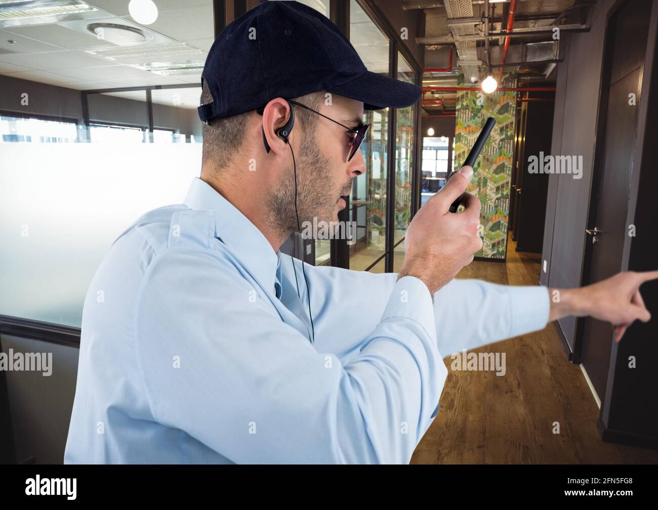 Composition of male security guard using walkie talkie holding hand out ...