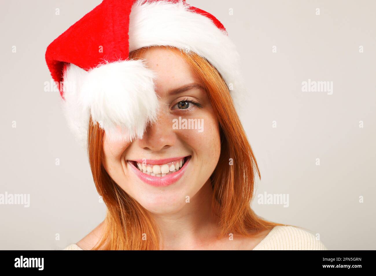 Close up portrait of beautiful redheaded young woman wearing Santa ...