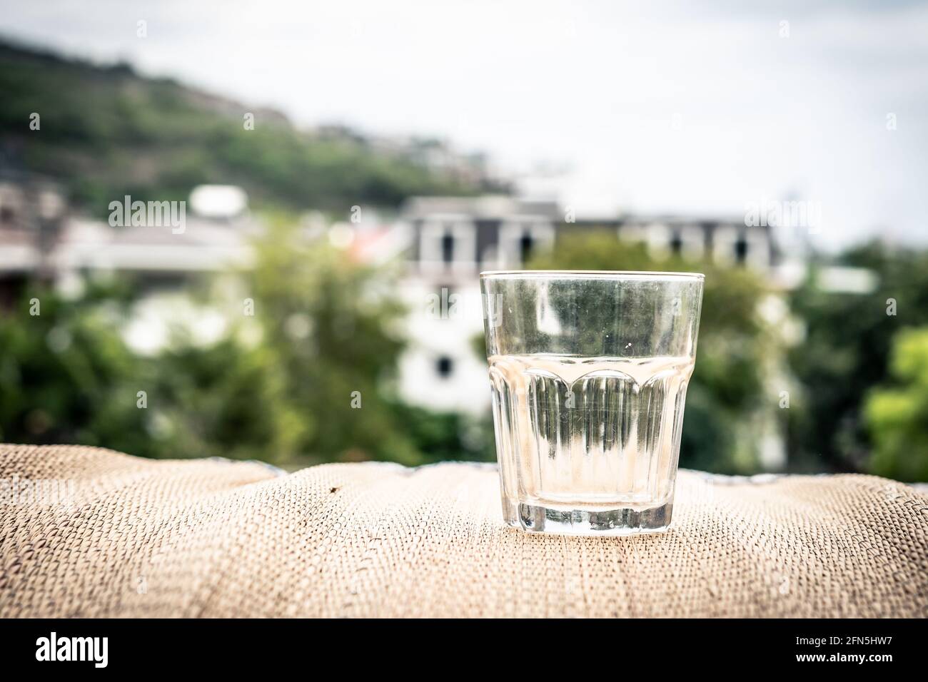 Close-up empty shabby old glass with limescale. Textured bamboo wooden ...
