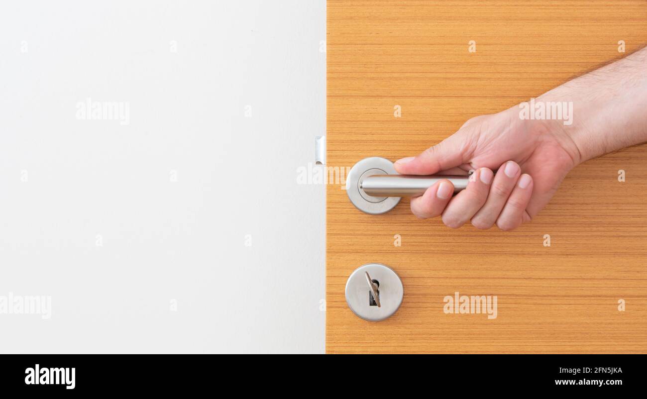 hand holding metal door handle. Front view Stock Photo - Alamy