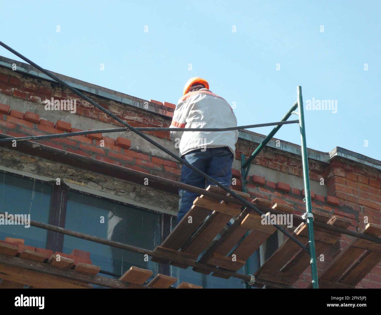 workpeople on ledge at day Stock Photo - Alamy