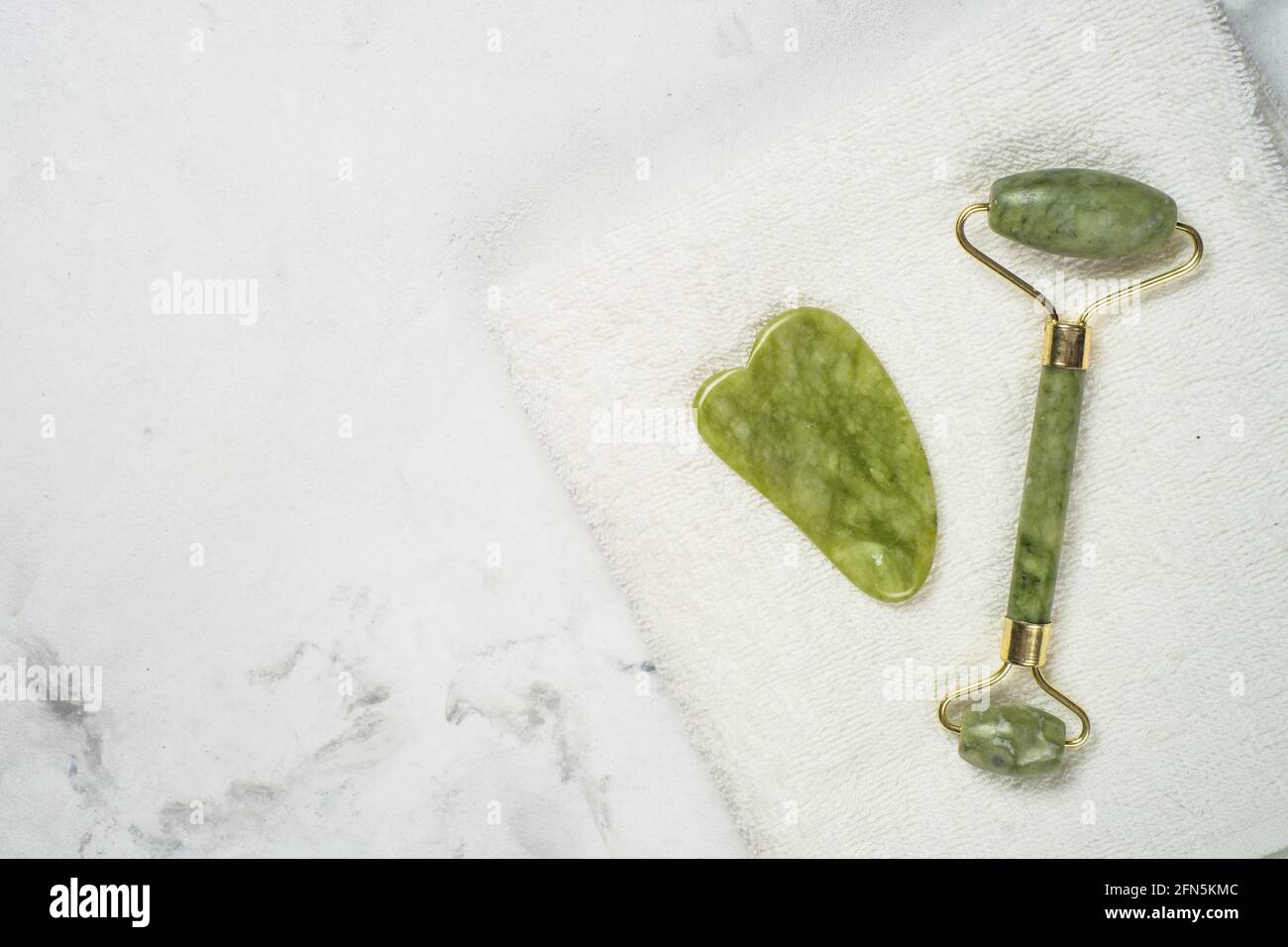 Jade roller and gua sha stone massager for face Stock Photo - Alamy