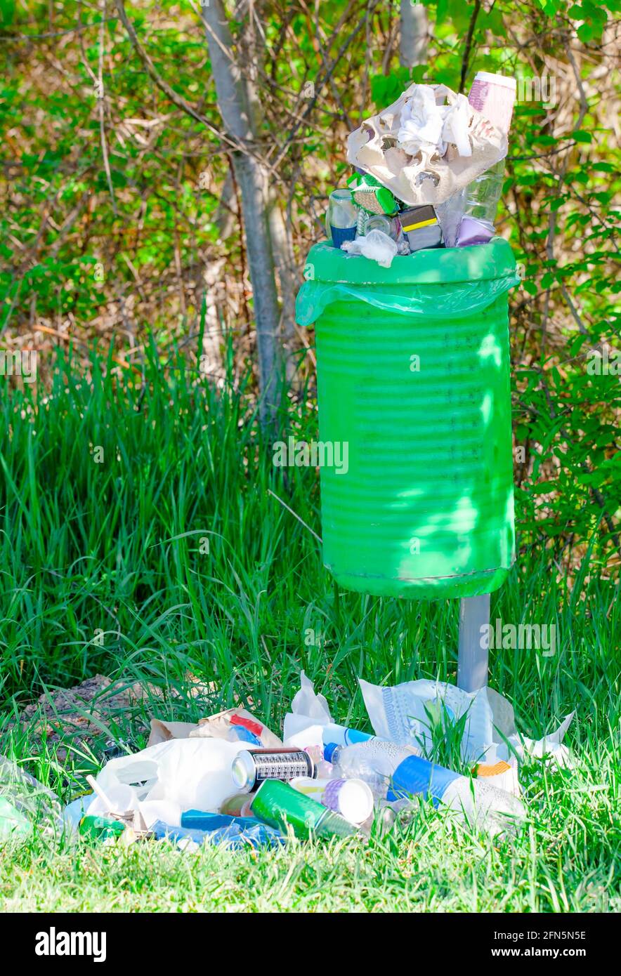 recycle bin full of garbage in nature Stock Photo - Alamy