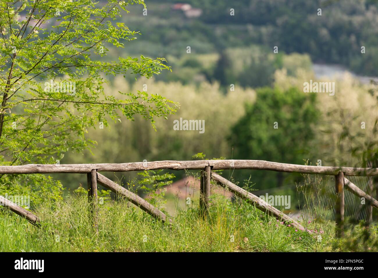 Fence in the mountains made of old tree trunks. Rural roads in the ...