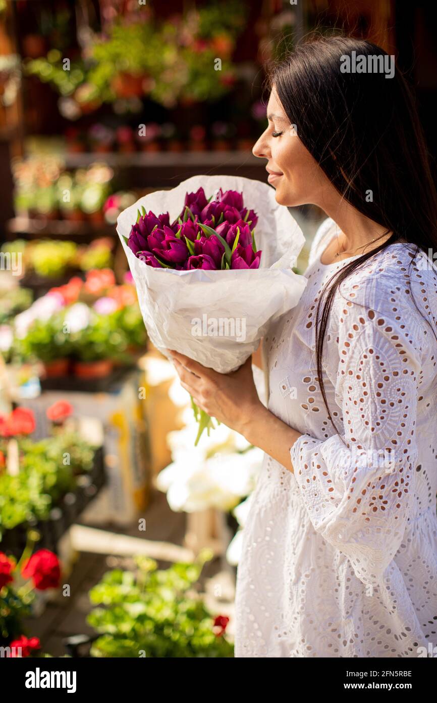 Pretty young woman buying flowers at the flower market Stock Photo - Alamy