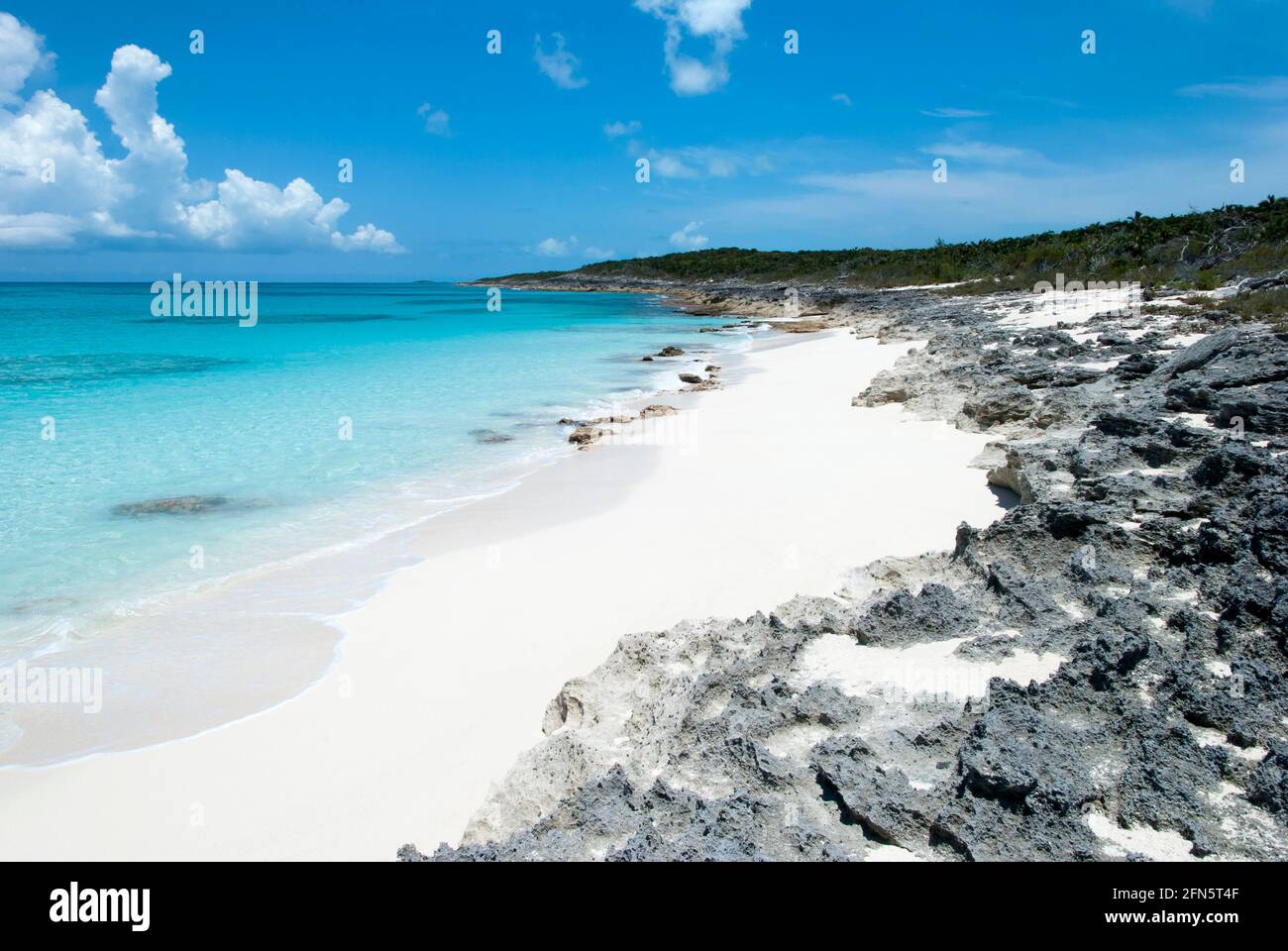 The scenic view of a small sandy beach surrounded by sharp rocks on ...