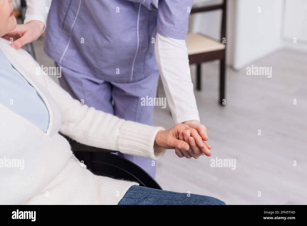 partial view of social worker holding hand and touching shoulder of ...