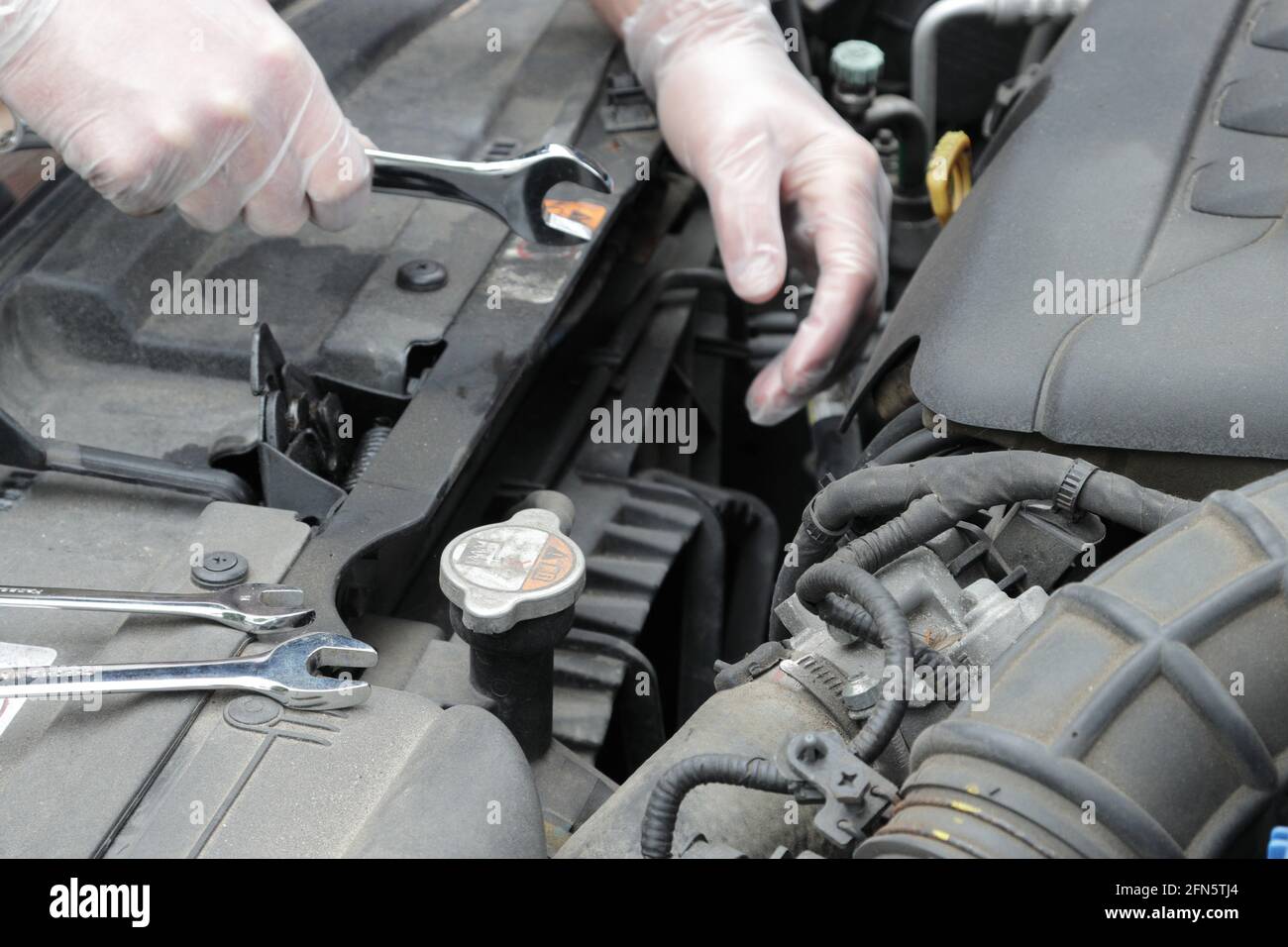 A mechanic's hands fixing a car engine Stock Photo - Alamy