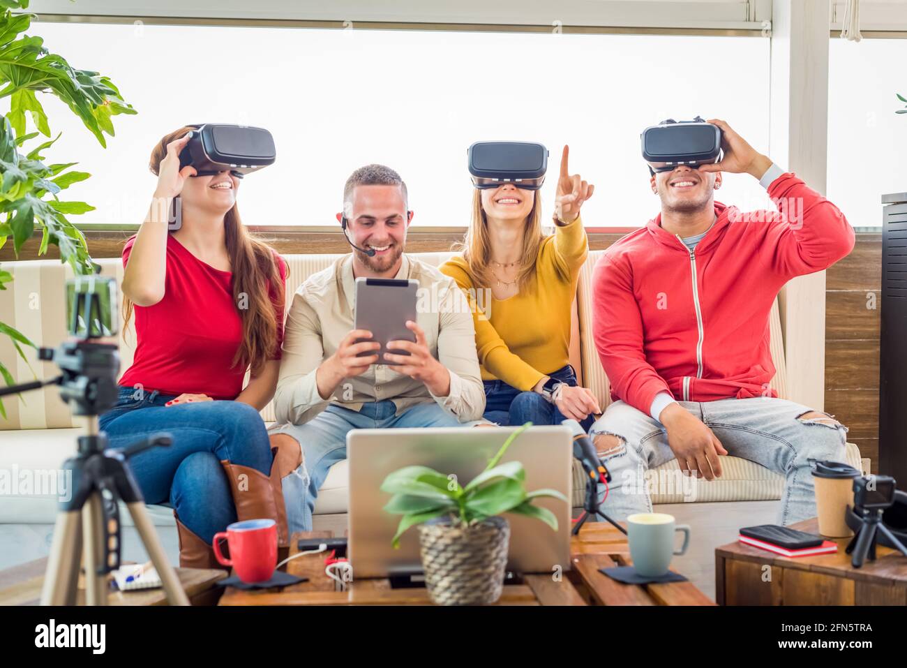 Young students wearing virtual reality glasses indoor. five people ...