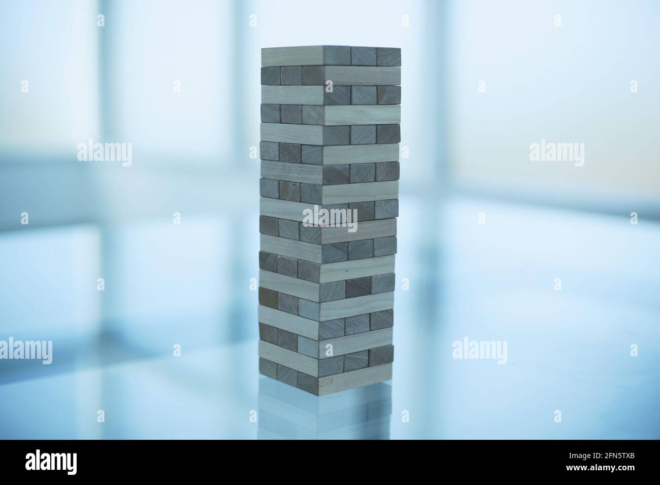 The tower from wooden blocks on glass table Stock Photo - Alamy