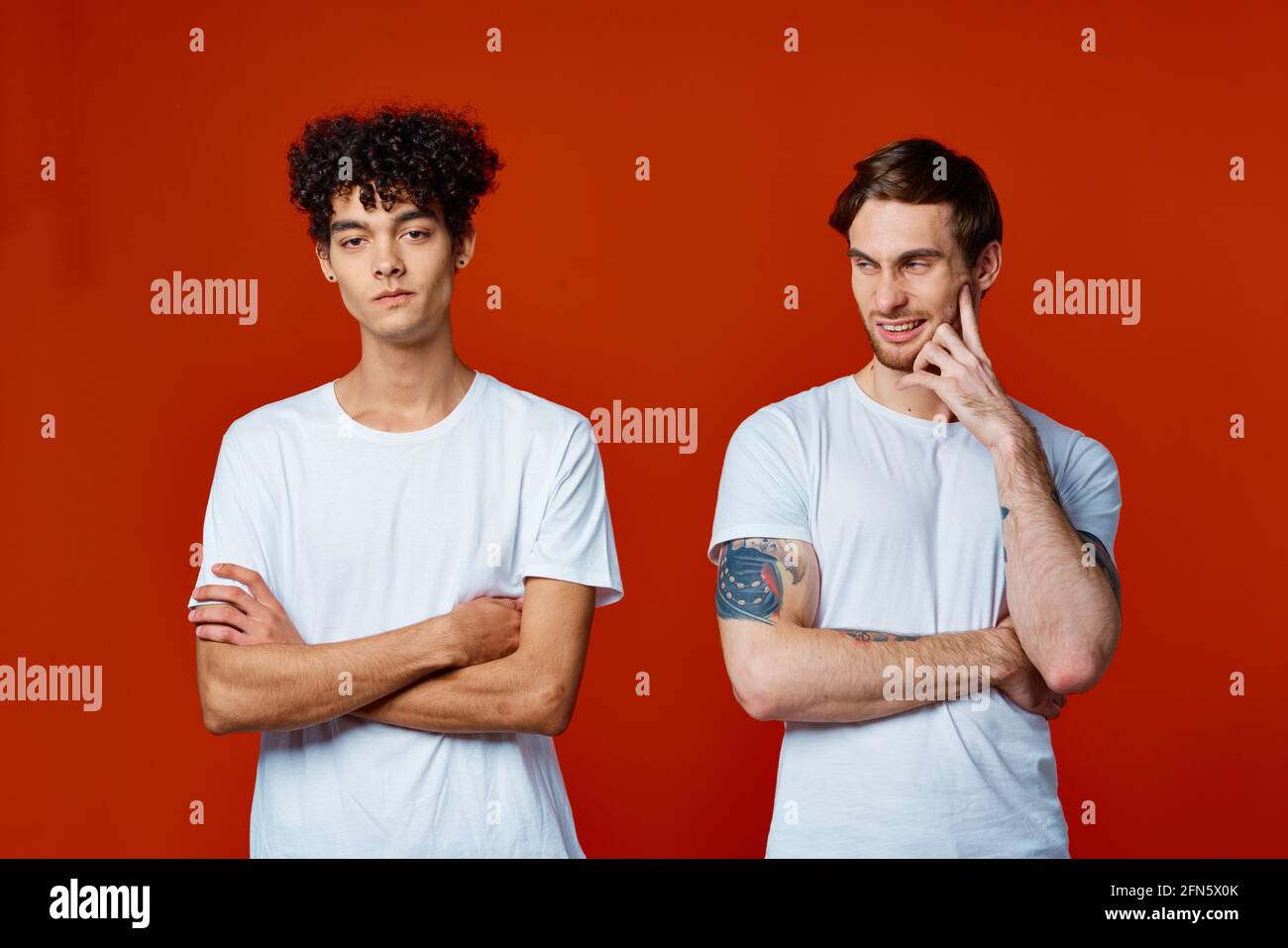 two friends in white t-shirts communication lifestyle red background ...