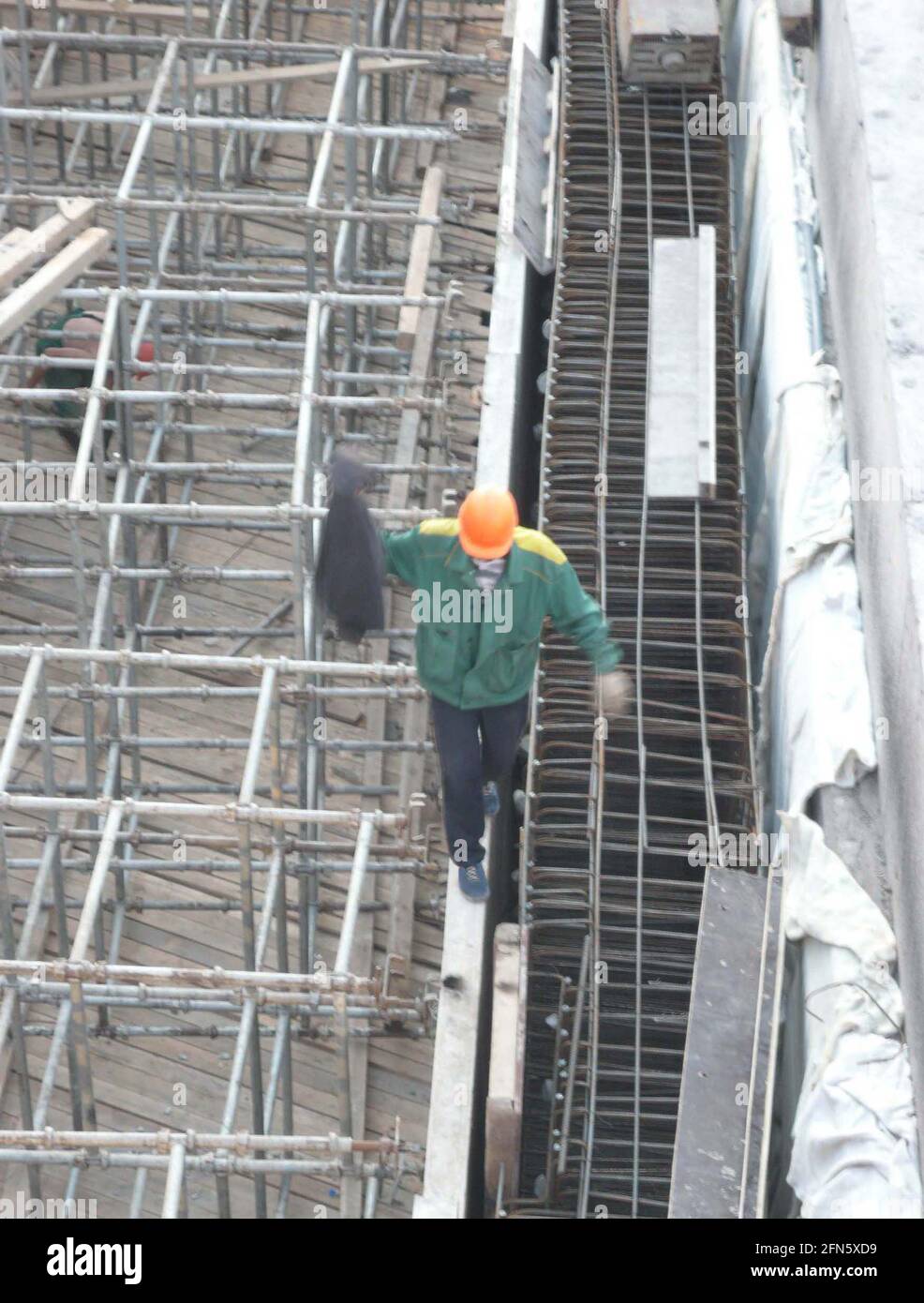 workpeople balance on ledge at day Stock Photo - Alamy