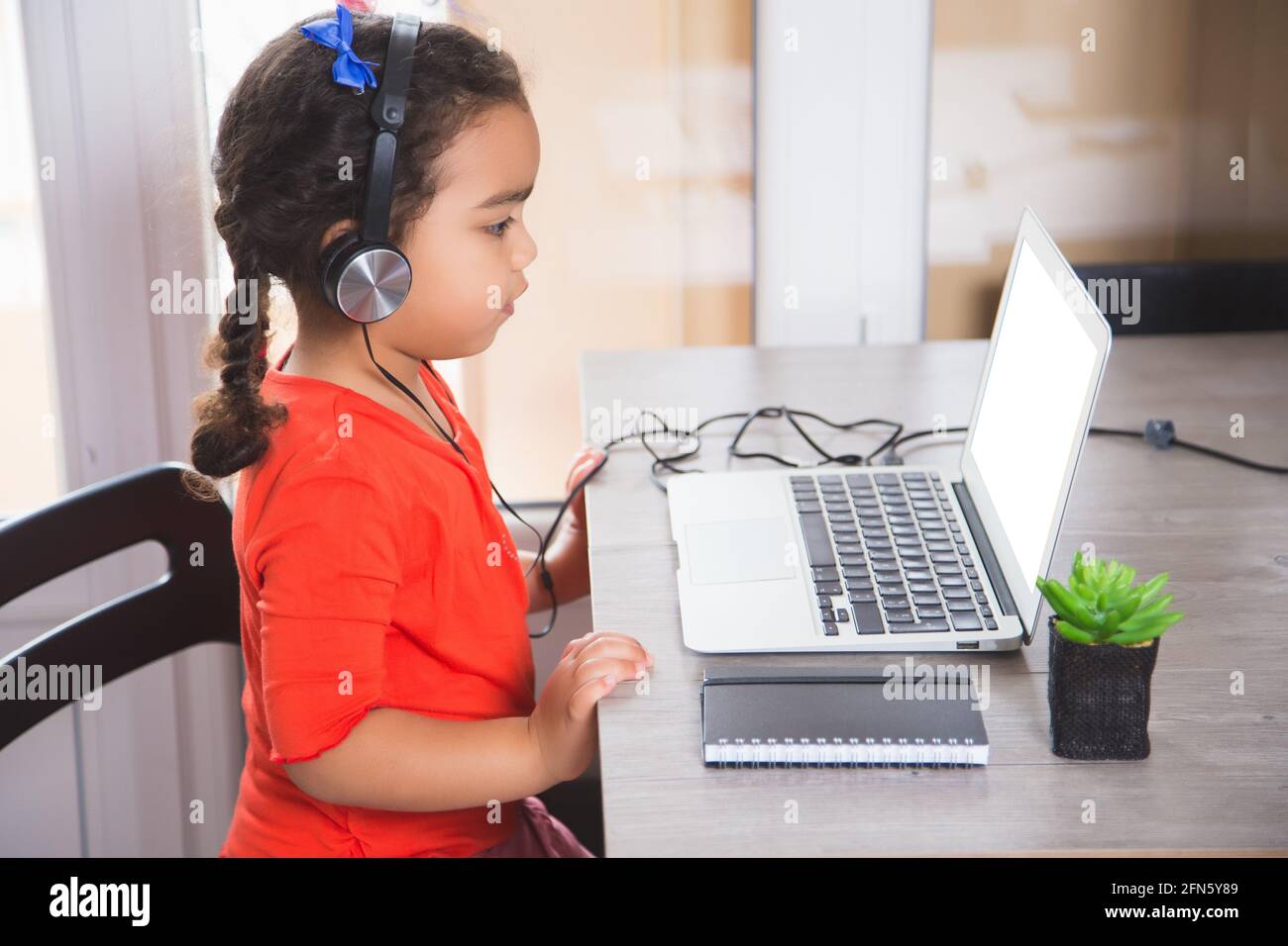 baby studying at home with his laptop and headphones . distance ...
