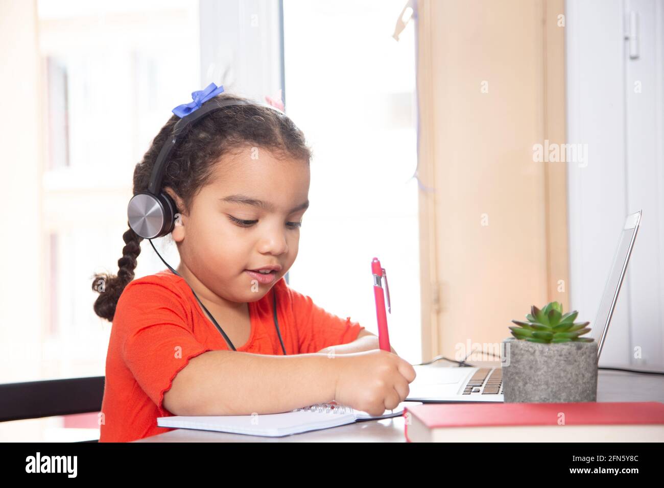 baby studying at home with his laptop and headphones . distance ...