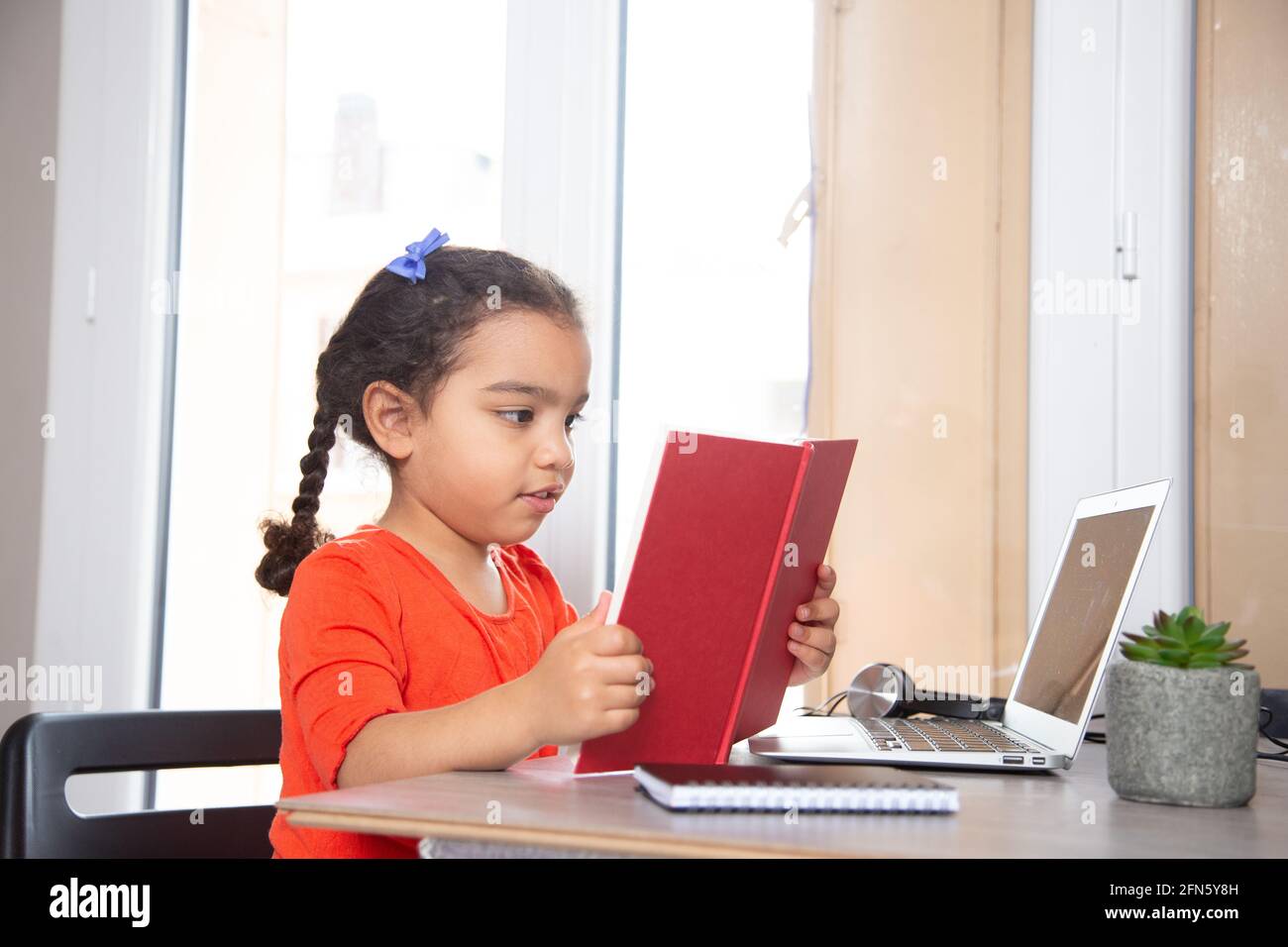 baby studying at home with his laptop and headphones . distance ...