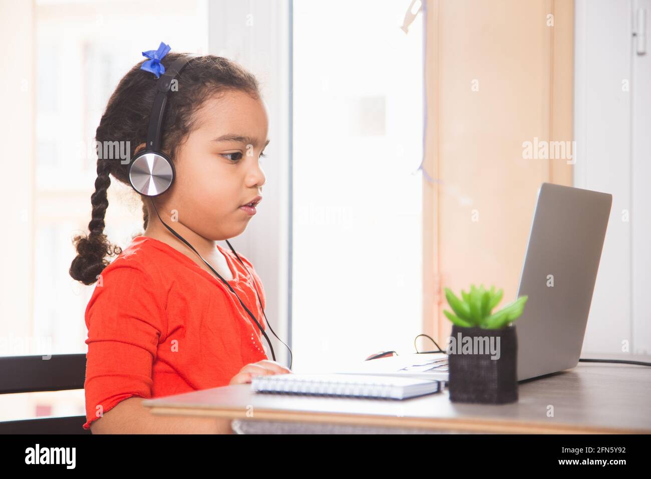 baby studying at home with his laptop and headphones . distance ...