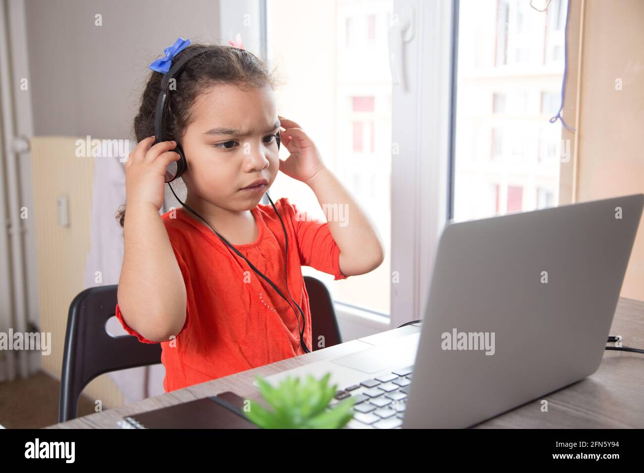 baby studying at home with his laptop and headphones . distance ...