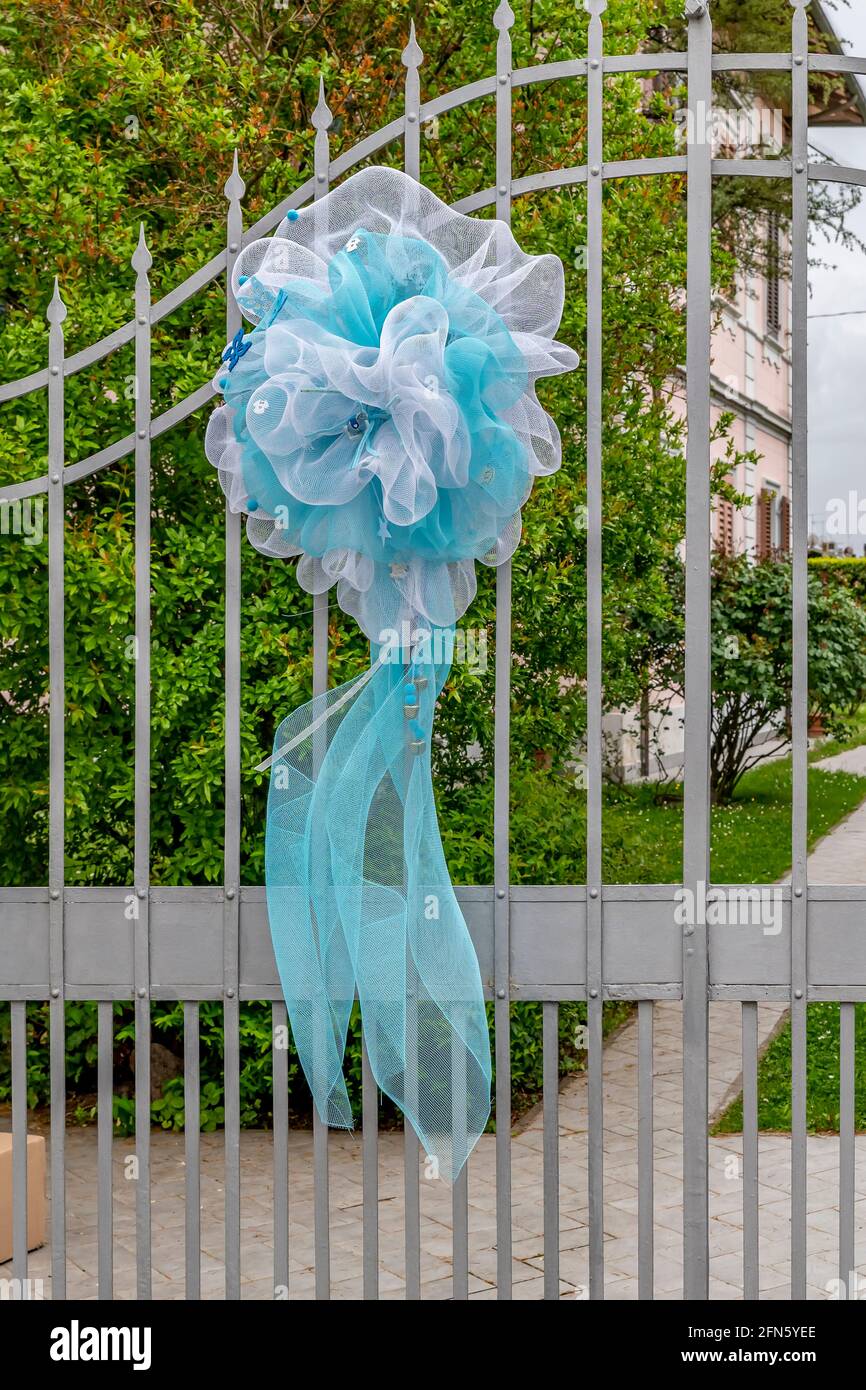 A large blue ribbon attached to the gate of a villa announces the birth ...