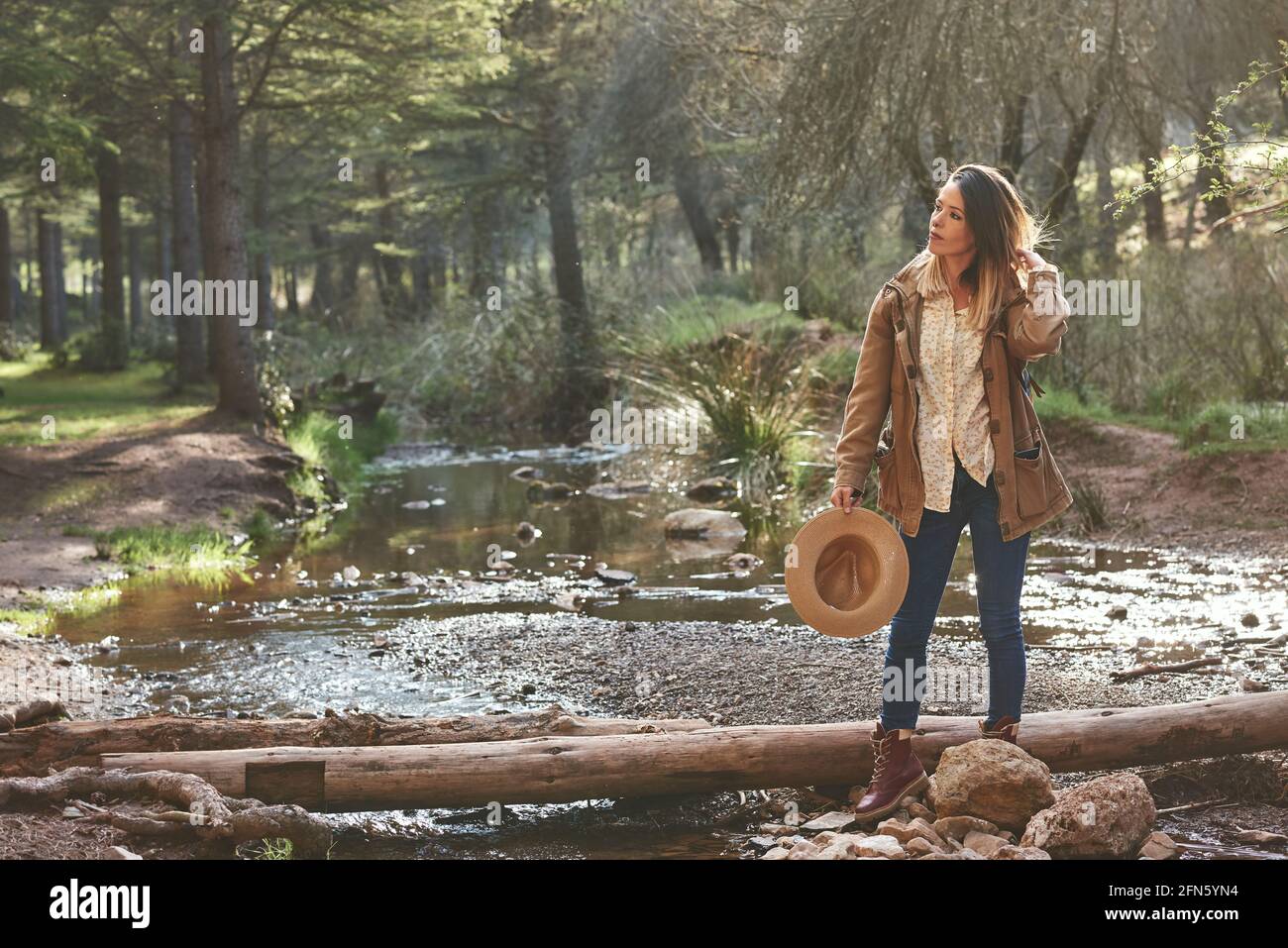 Woman on the mountain. She is in a forest with pine trees Stock Photo ...
