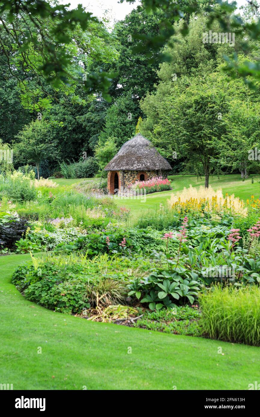 The thatched roof Dell Summer House, Bressingham Gardens, a steam ...