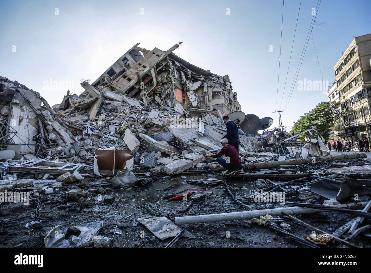 Palestinians inspect the rubble of the destroyed Al-Shorouq tower after ...