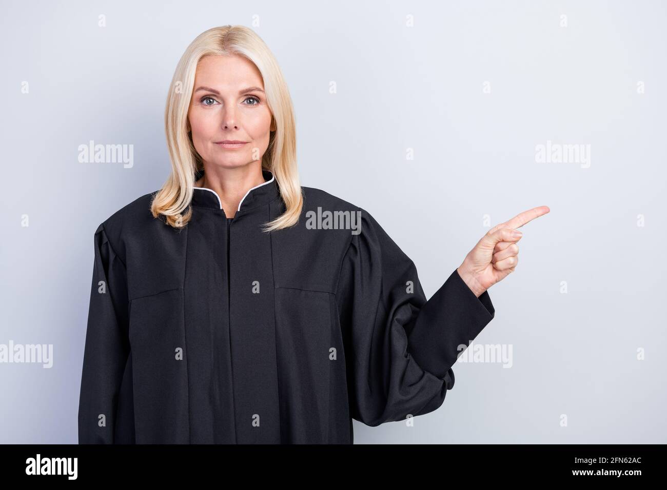 Portrait of attractive serious confident woman judge demonstrating copy ...