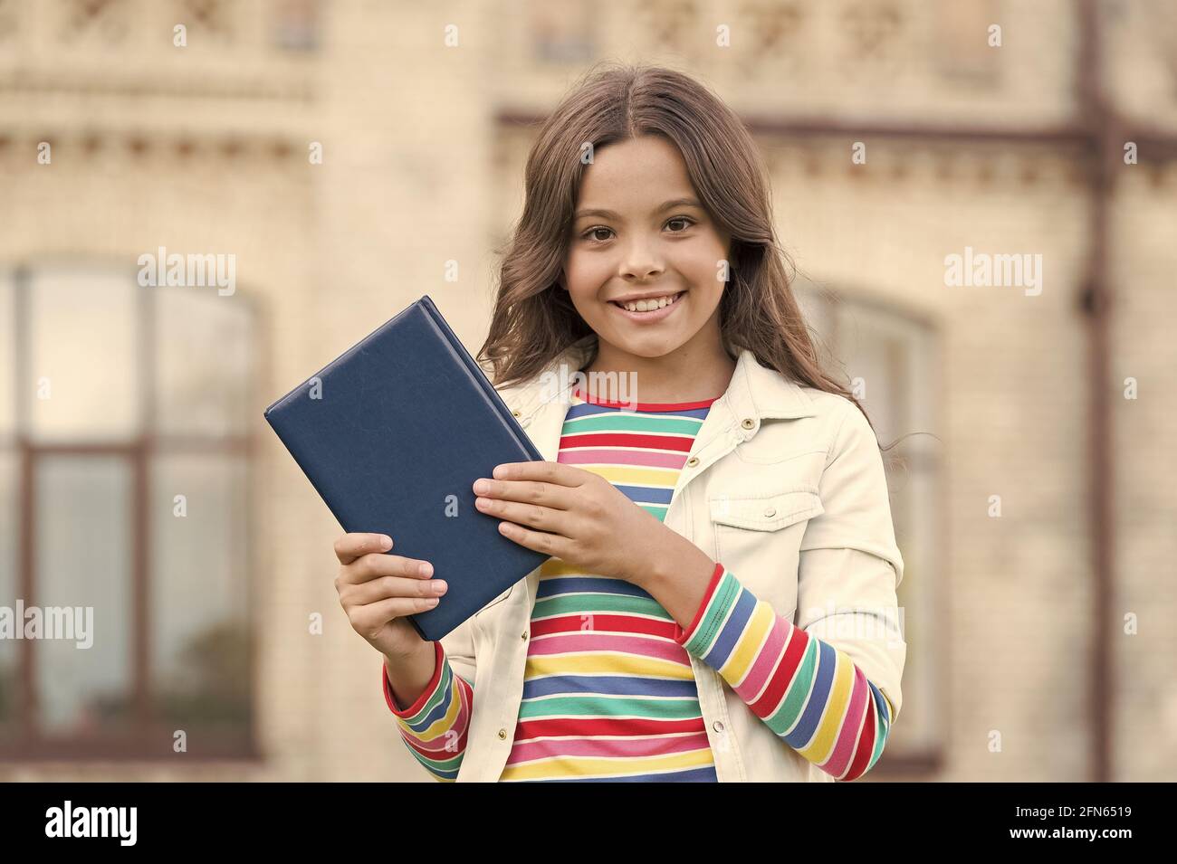 Smart library is open. Happy child hold library book outdoors. Little ...