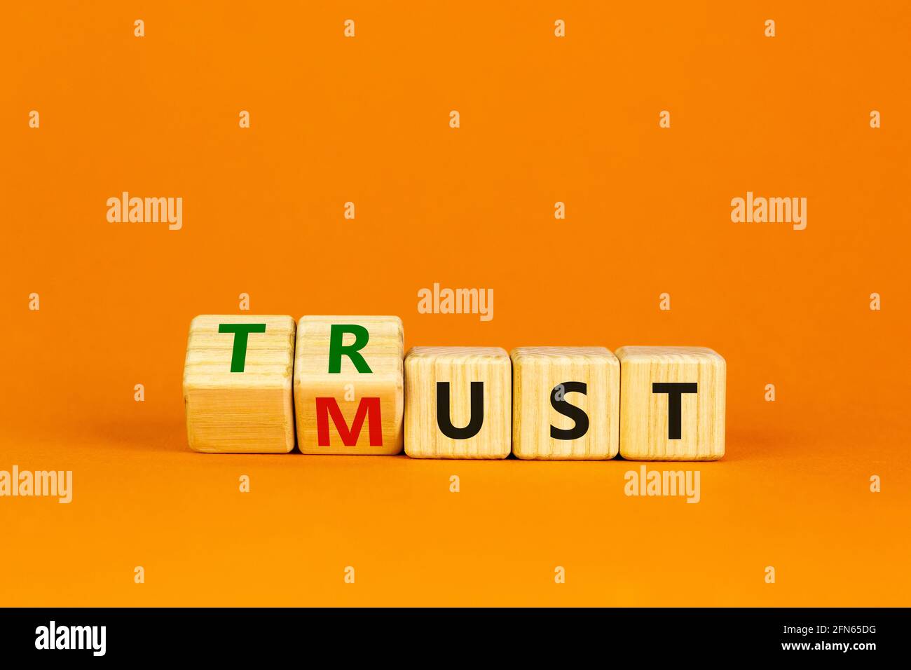 Must trust symbol. Turned wooden cubes with words 'must trust ...
