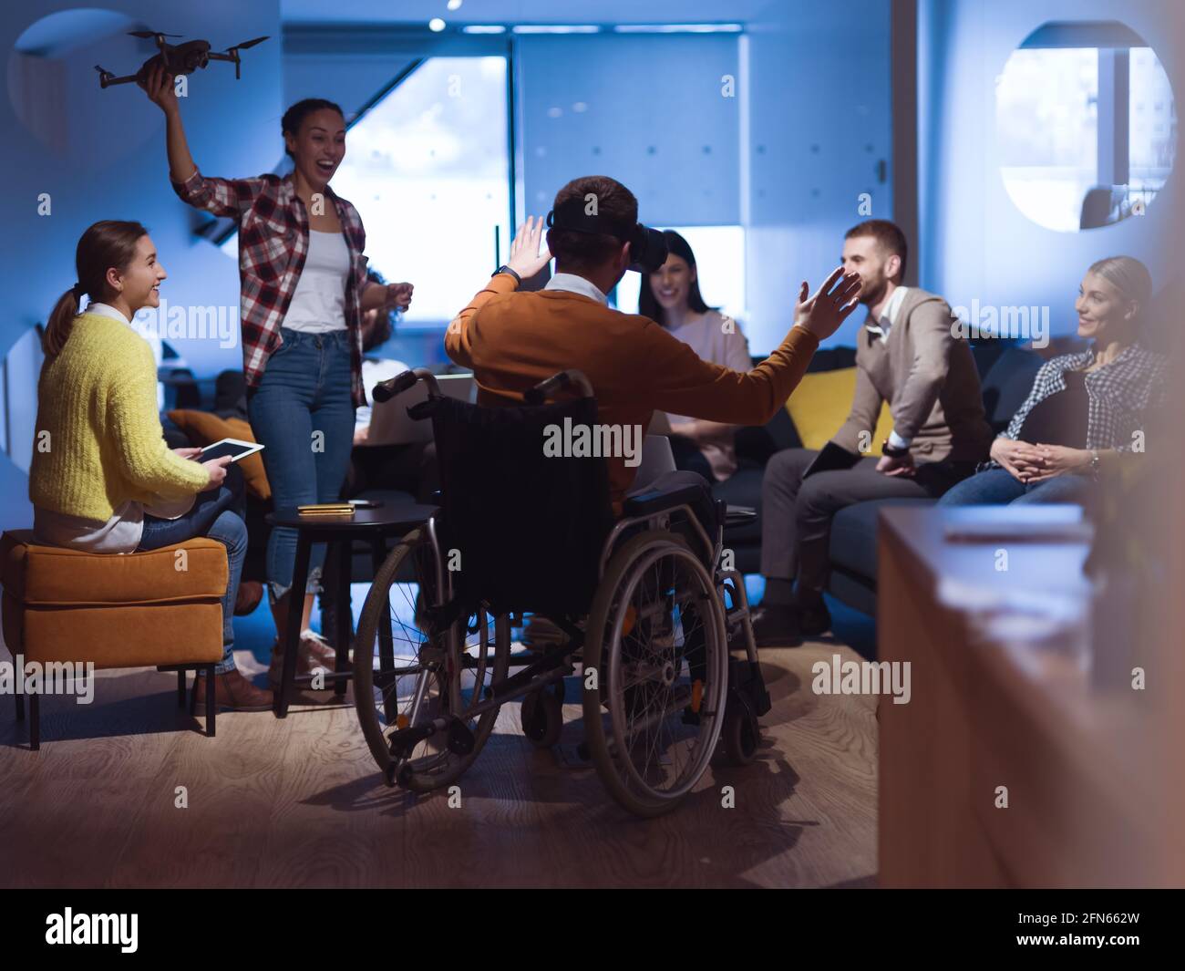 Disabled businessman in a wheelchair at work in modern open space ...