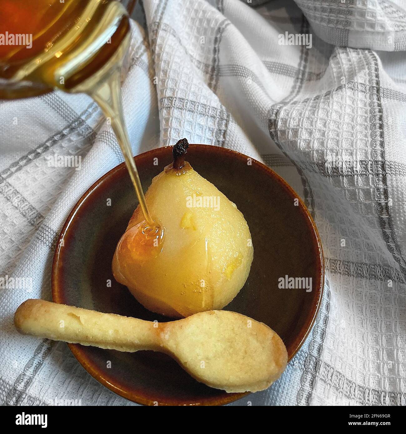 Poached Pear Drizzled with Honey with Shortbread Cookie Spoon Stock ...