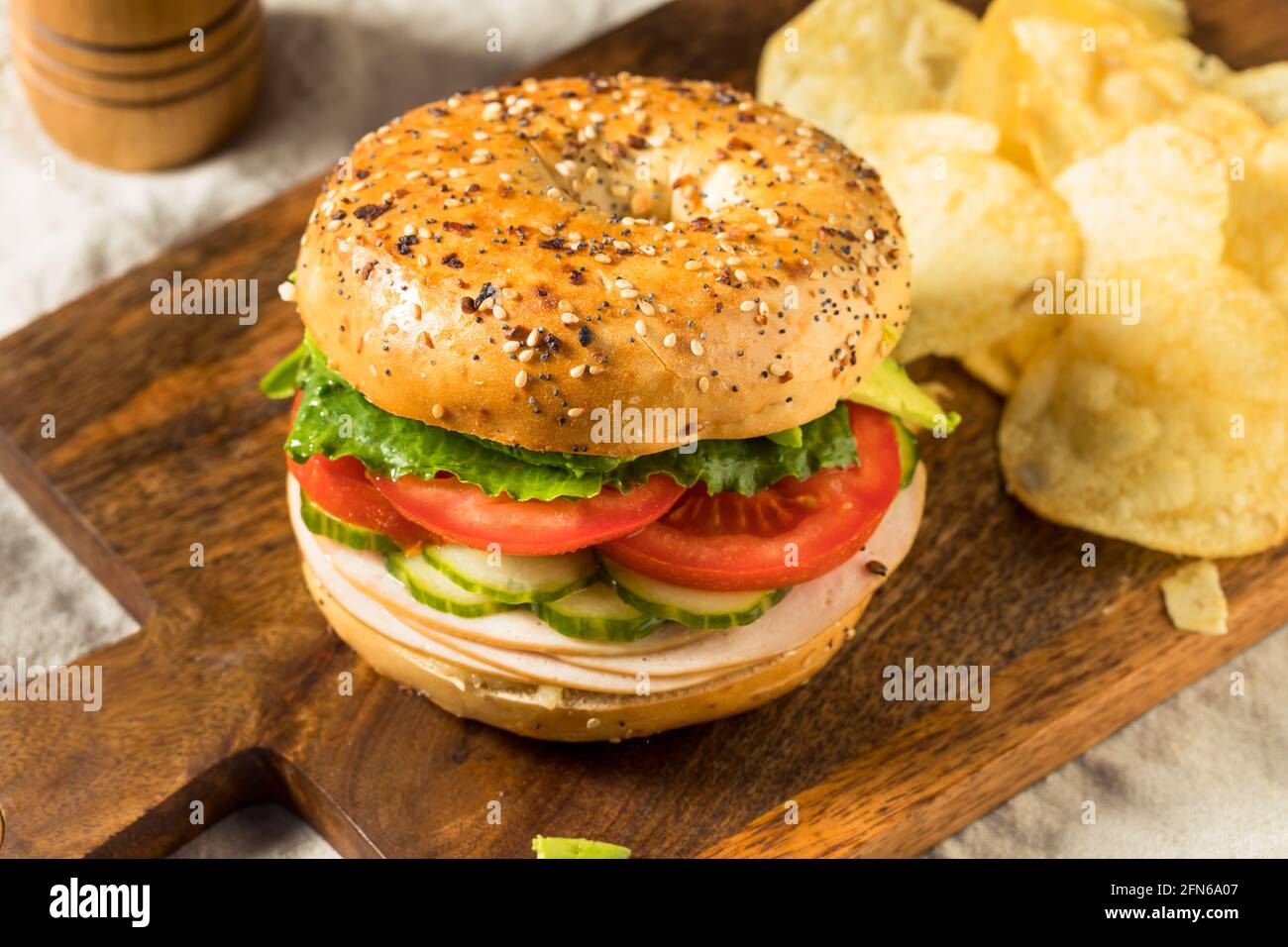 Homemade Bagel Turkey Sandwich with Lettuce Tomato and Chips Stock ...