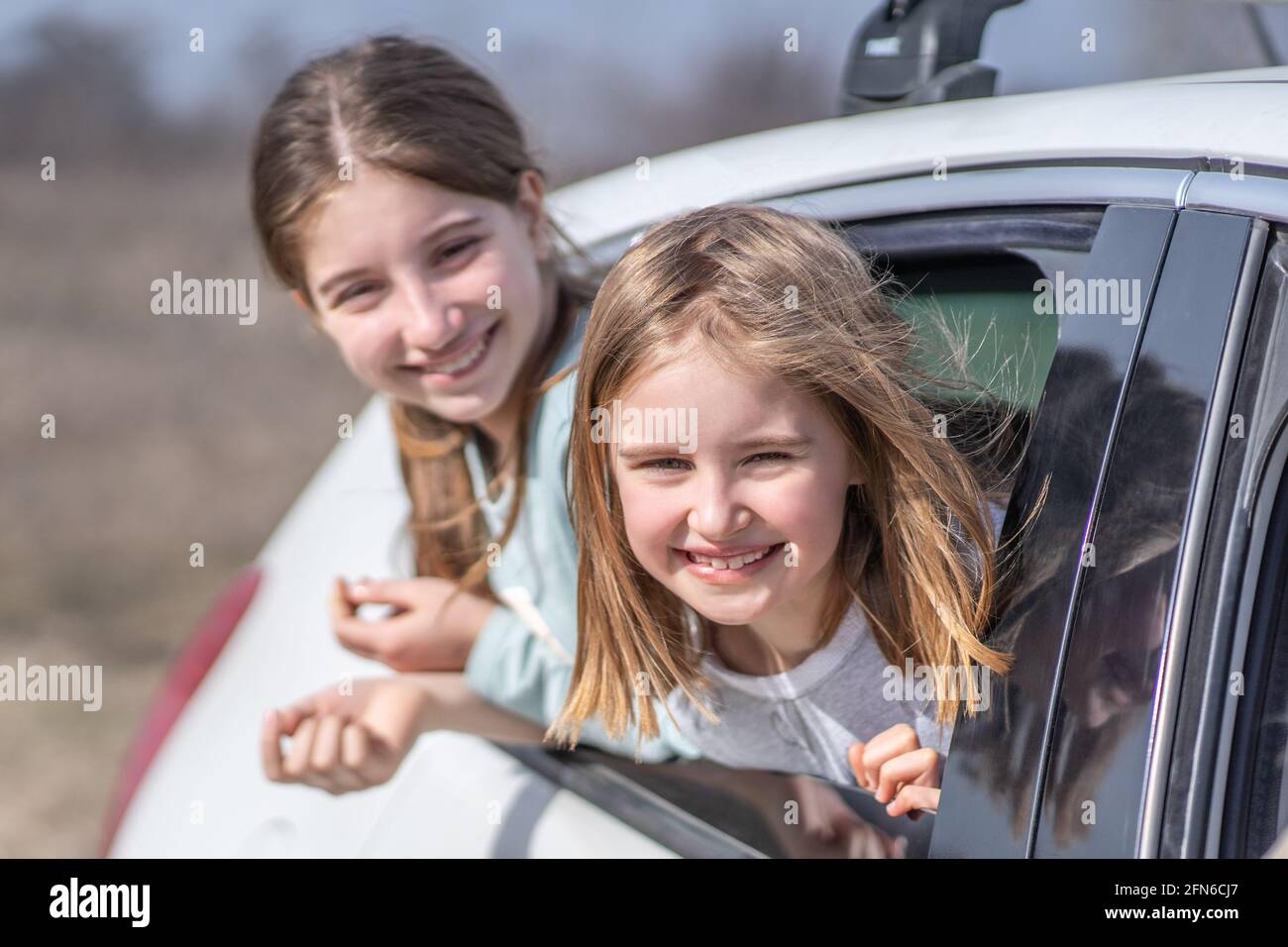 Happy girls looking out of car window at sunny day Stock Photo - Alamy