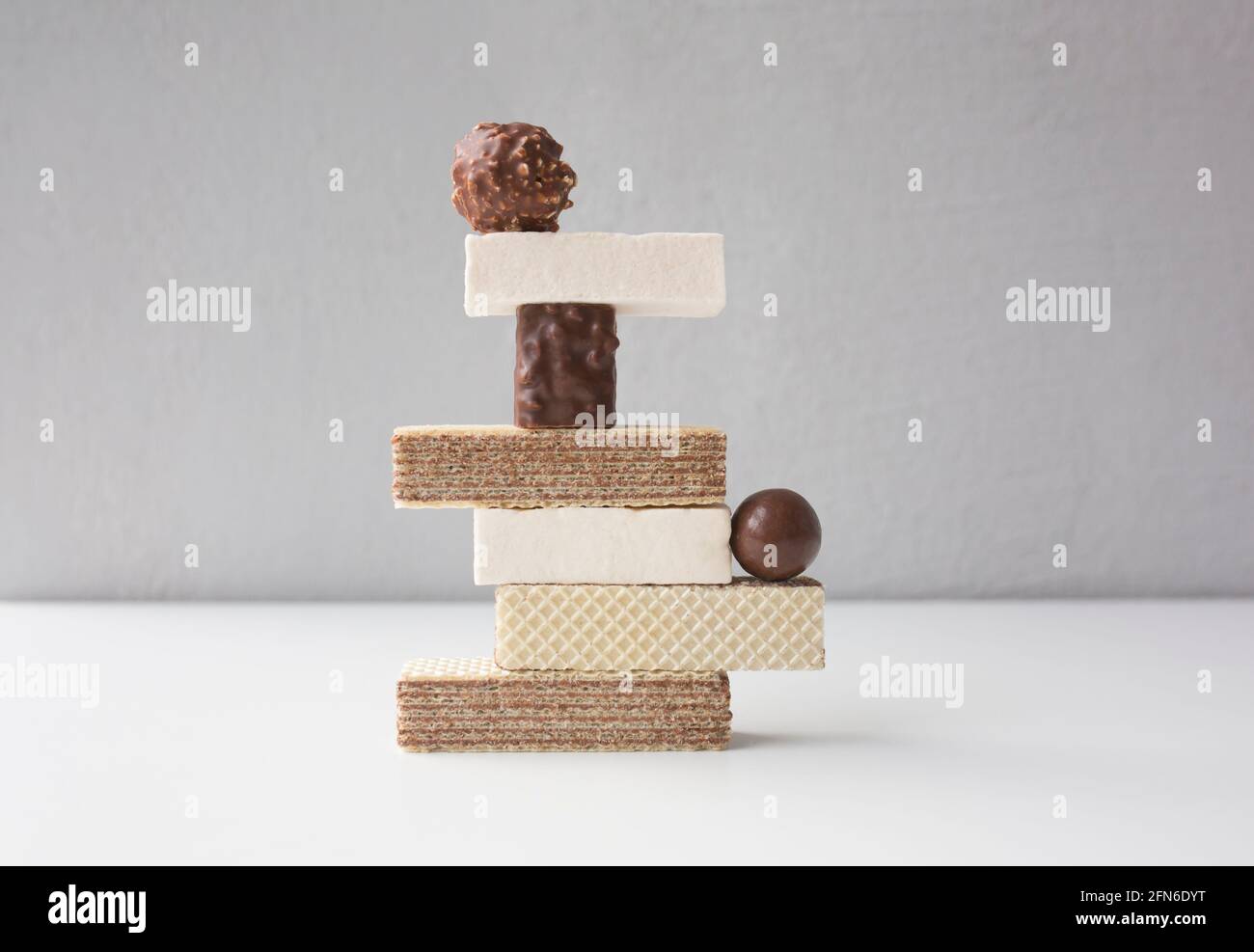 Stack of sweet snacks on white table. Balance concept Stock Photo - Alamy
