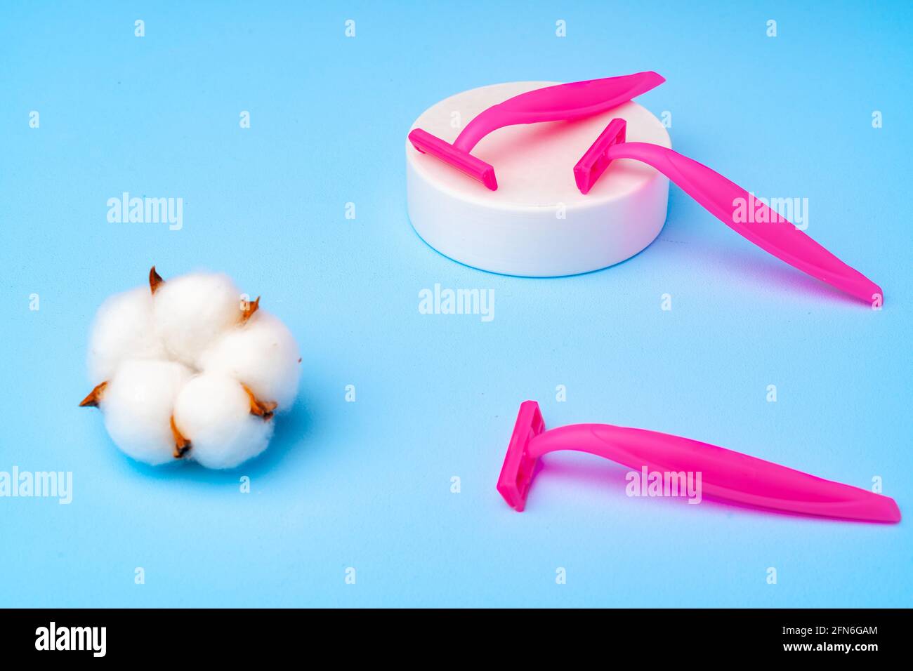 Pink disposable razors and cotton flower on blue paper Stock Photo - Alamy