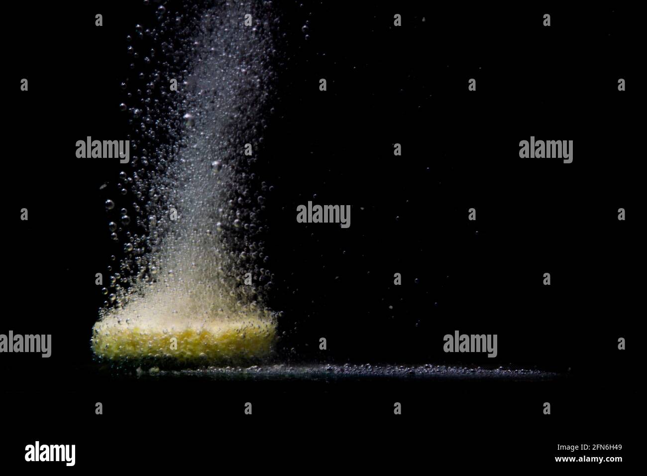 Effervescent tablet in water on black background Stock Photo - Alamy