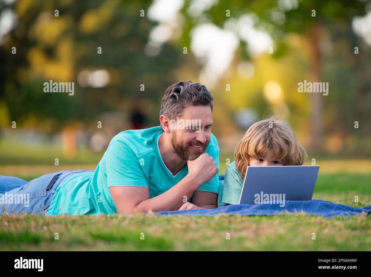 Father teaching son to use laptop, dad and school boy child looking ...